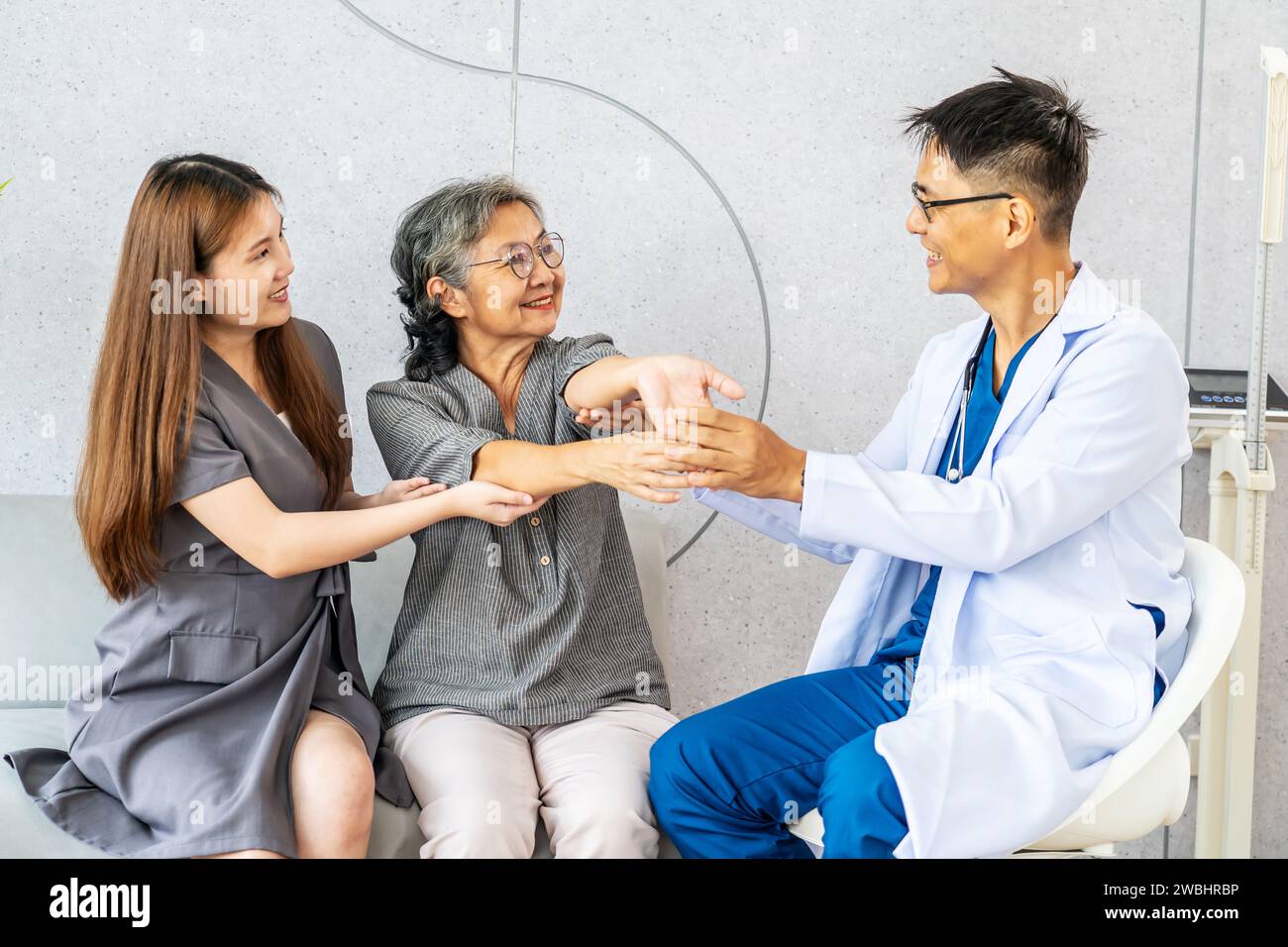 Male doctor teaching physical therapy to Asian senior adult patient and ...