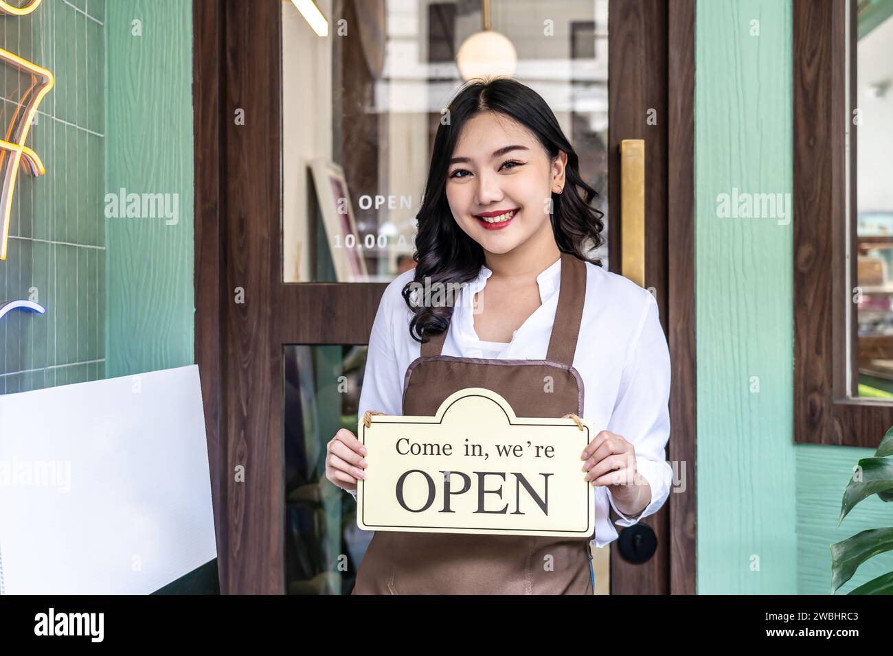 Business owner happy beautiful young asian woman in apron looking at ...