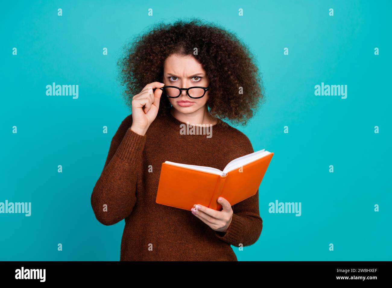 Photo of young angry woman working librarian with orange book and ...