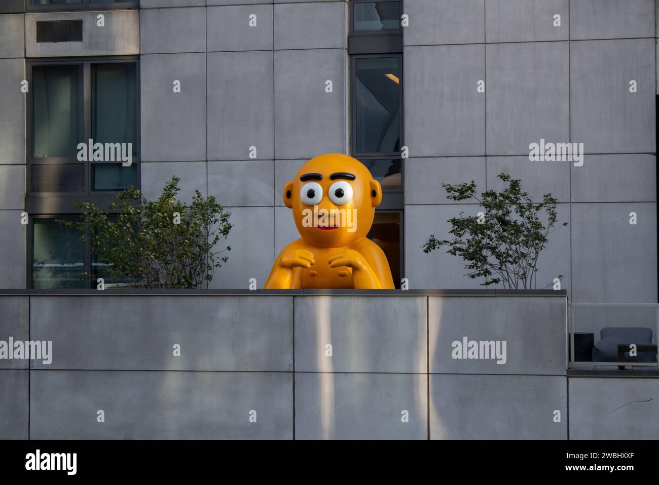 A vibrant yellow statue in front of a modern building in New York ...