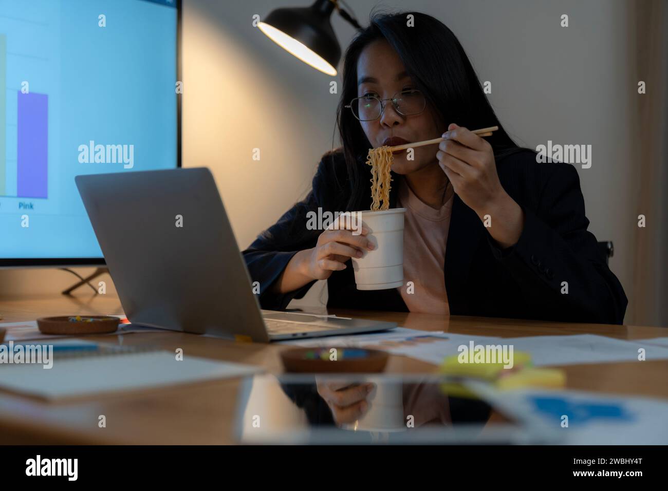 Asian businesswoman eating at computer hi-res stock photography and ...