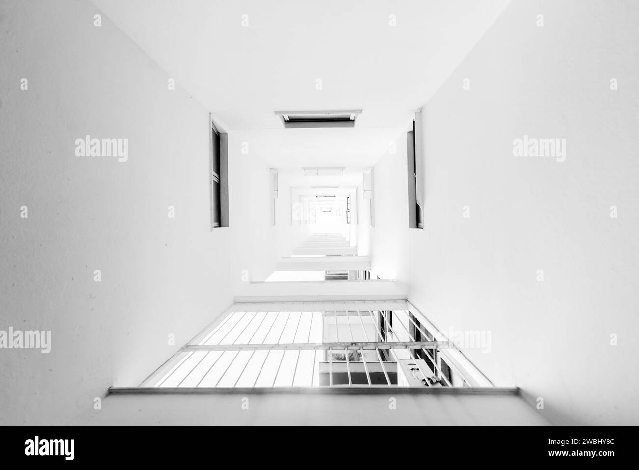 A spacious hallway featuring a single window at its end, providing a ...
