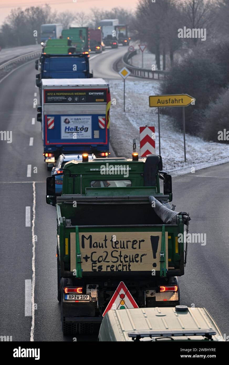 Vieselbach, Germany. 11th Jan, 2024. Trucks with banners drive in ...