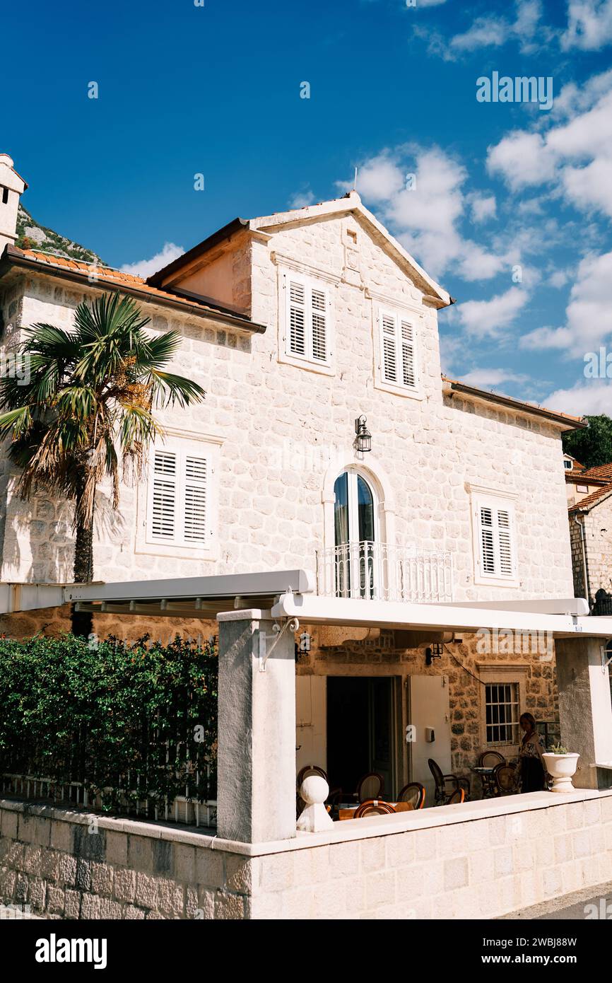 Covered terrace of an ancient stone house with an attic with chairs and ...