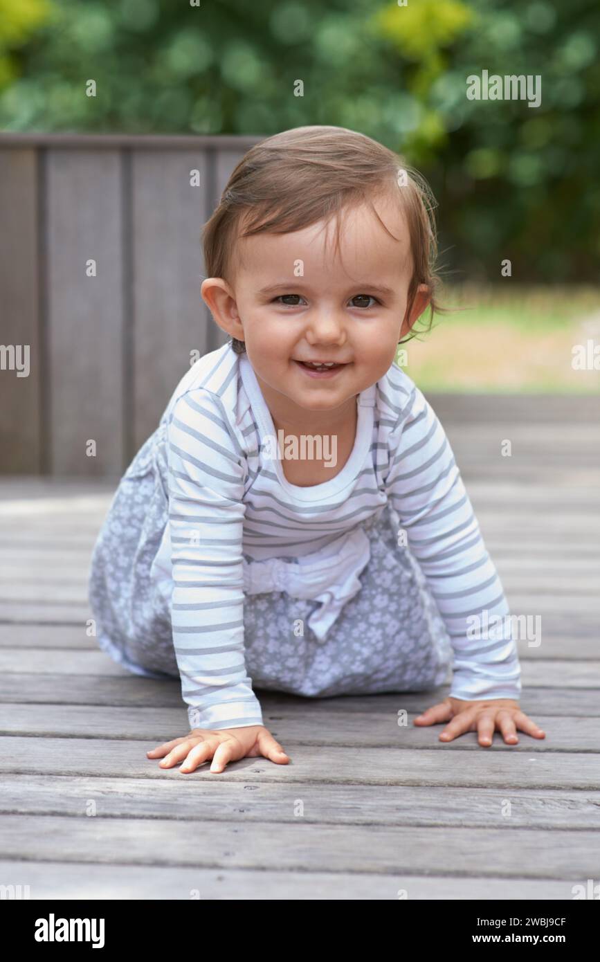 Baby girl, crawling outside and portrait on floor, child development ...