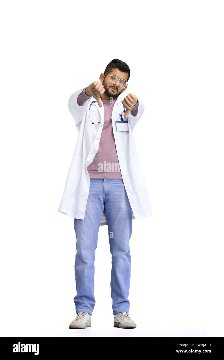 A male doctor, on a white background, in full height, shows his thumbs ...