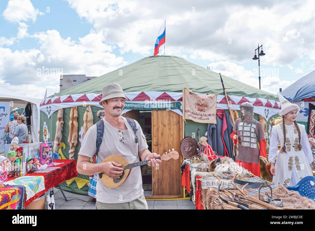 Senior Asian man jokingly playing national string instrument.Bashkir ...