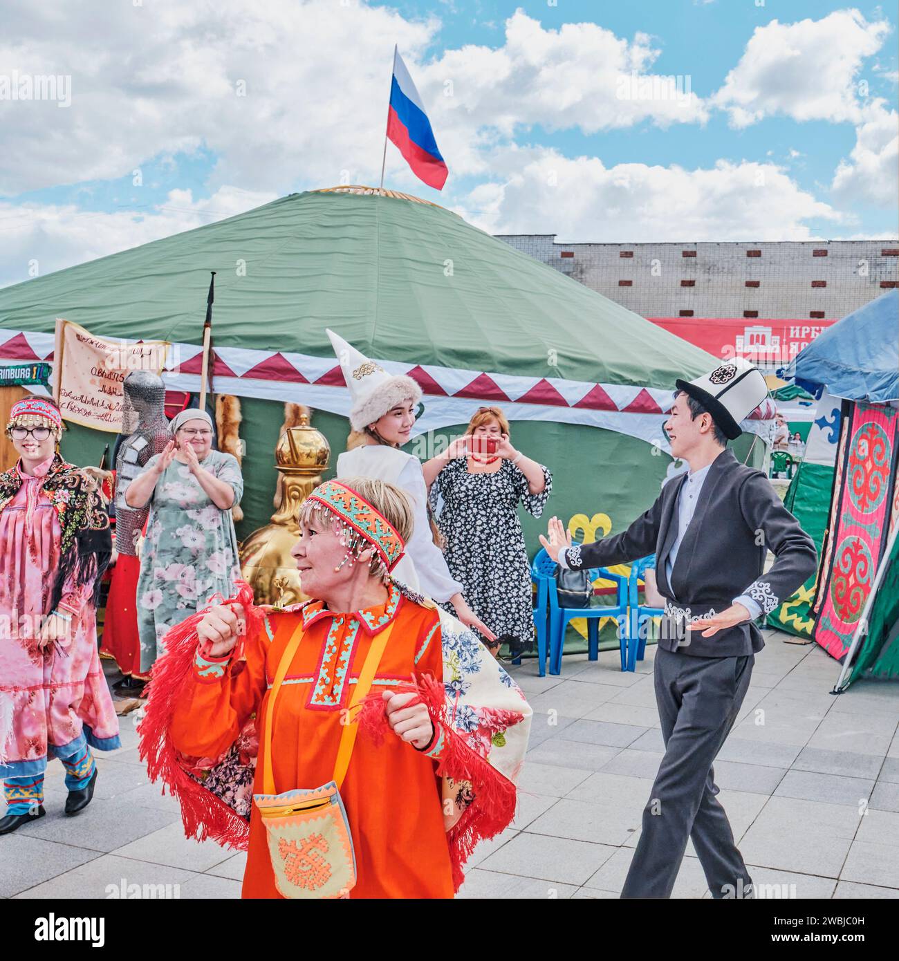 Senior woman in traditional festive clothes of Mansi people dancing ...