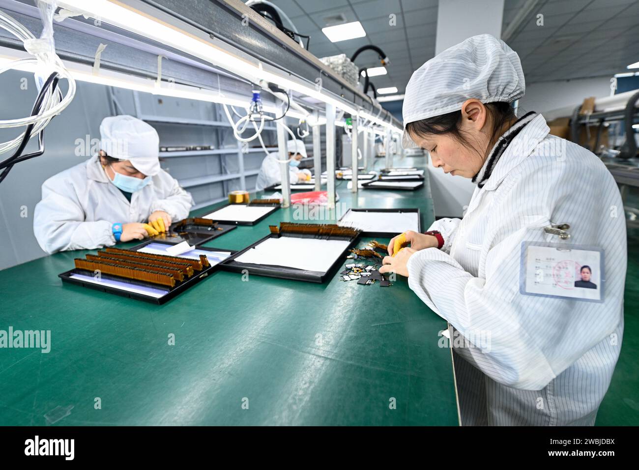 GAO'AN, CHINA - JANUARY 10, 2024 - A worker solders a crystal display ...