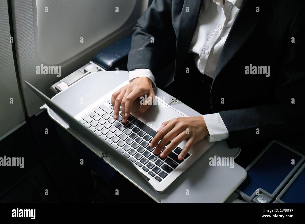 businesswoman flying and working in an airplane in first class, sitting ...