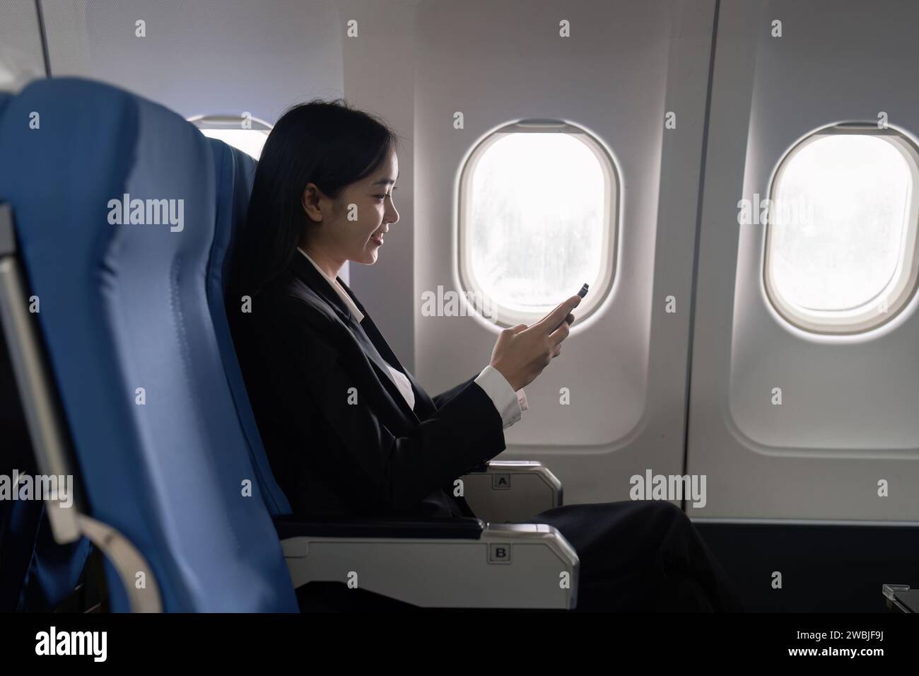 businesswoman flying and working in an airplane in first class, sitting ...