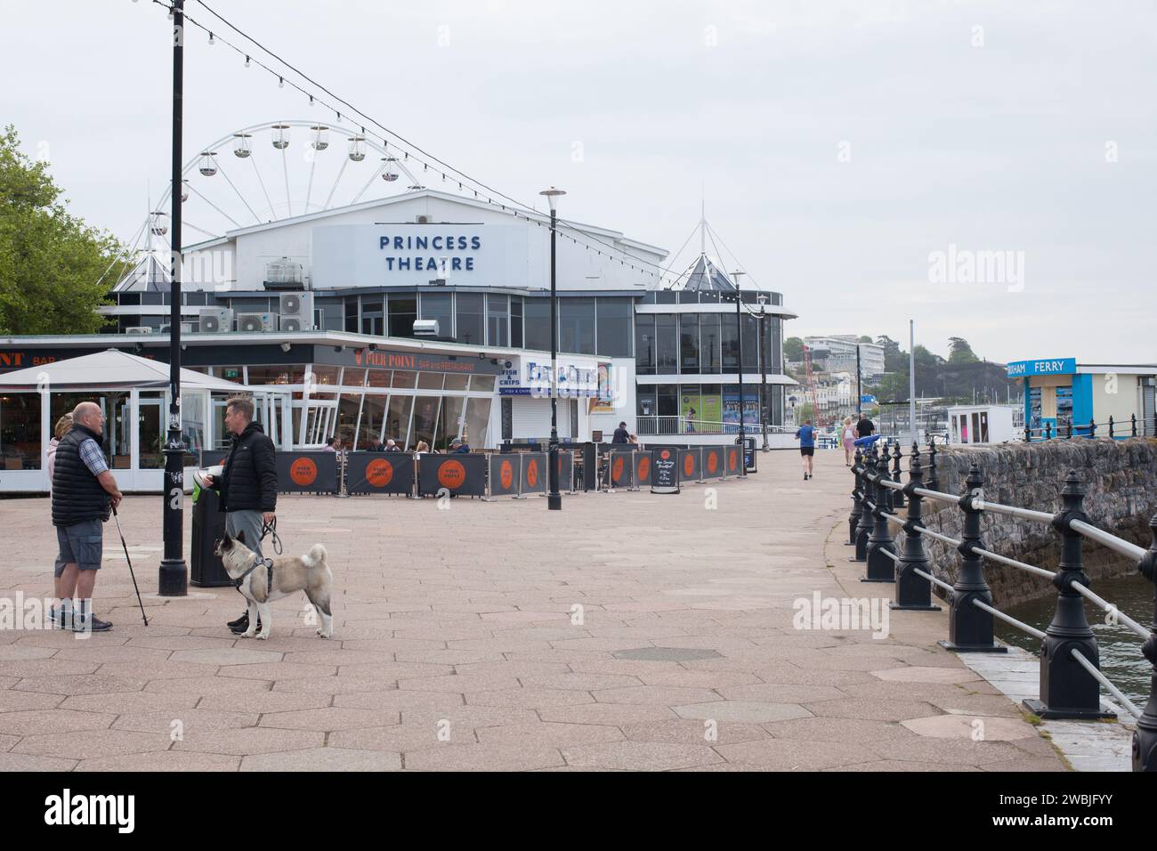 People stand by the Princess Theatre at the Marina in Torquay, Devon in ...