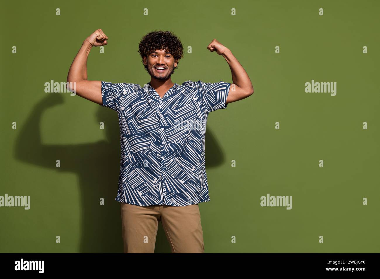 Photo of successful smiling bodybuilder guy ambitious sportsman showing ...