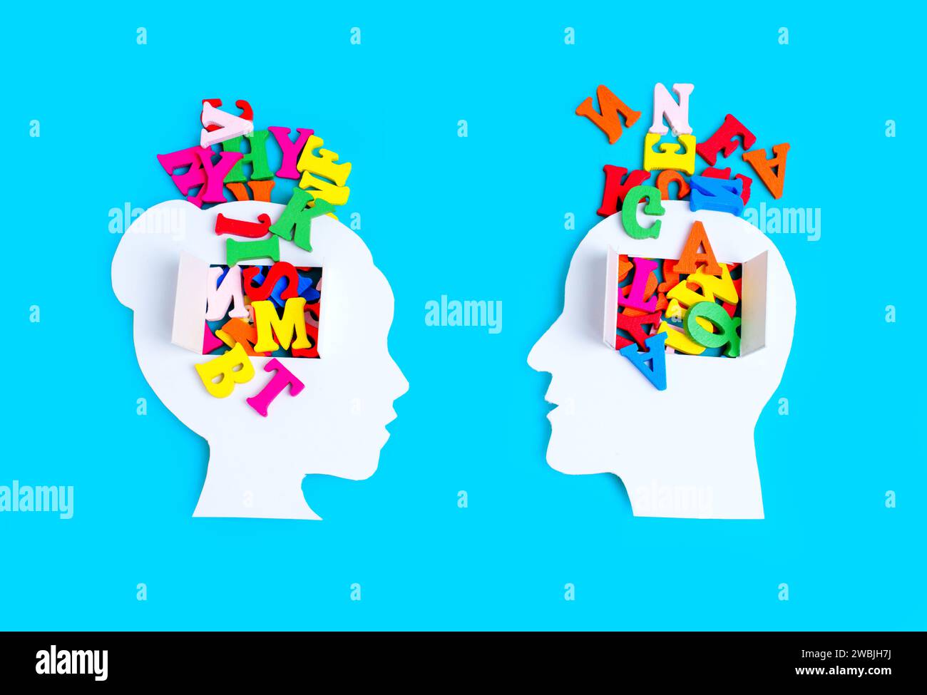 White paper-cut female and male heads, set against a blue backdrop ...