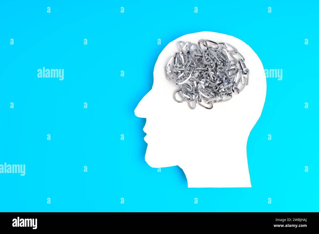 White paper silhouette of a male head in profile where a symbolic chain ...