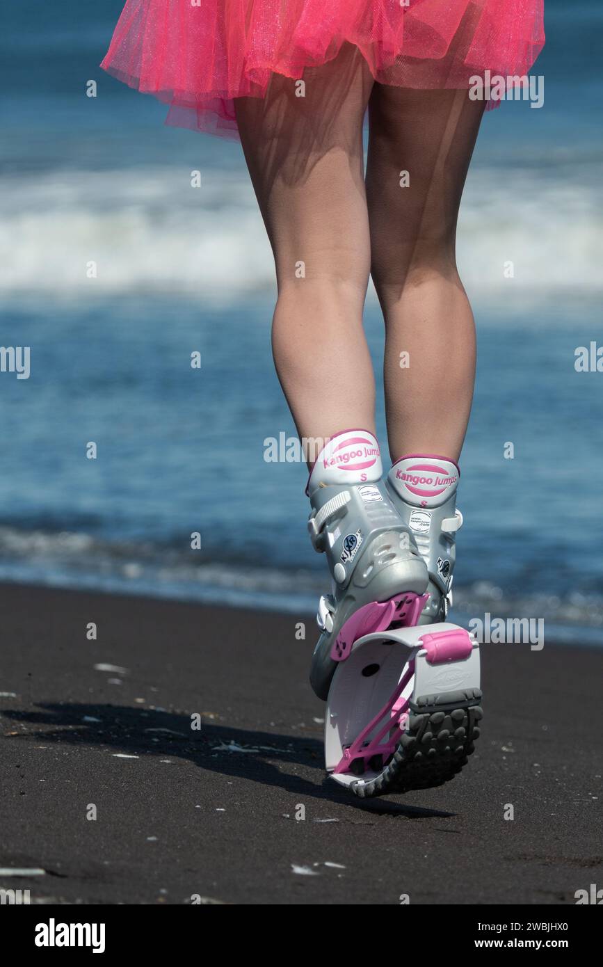Athletic woman legs in pink sports boots Kangoo Jumps and short skirt ...
