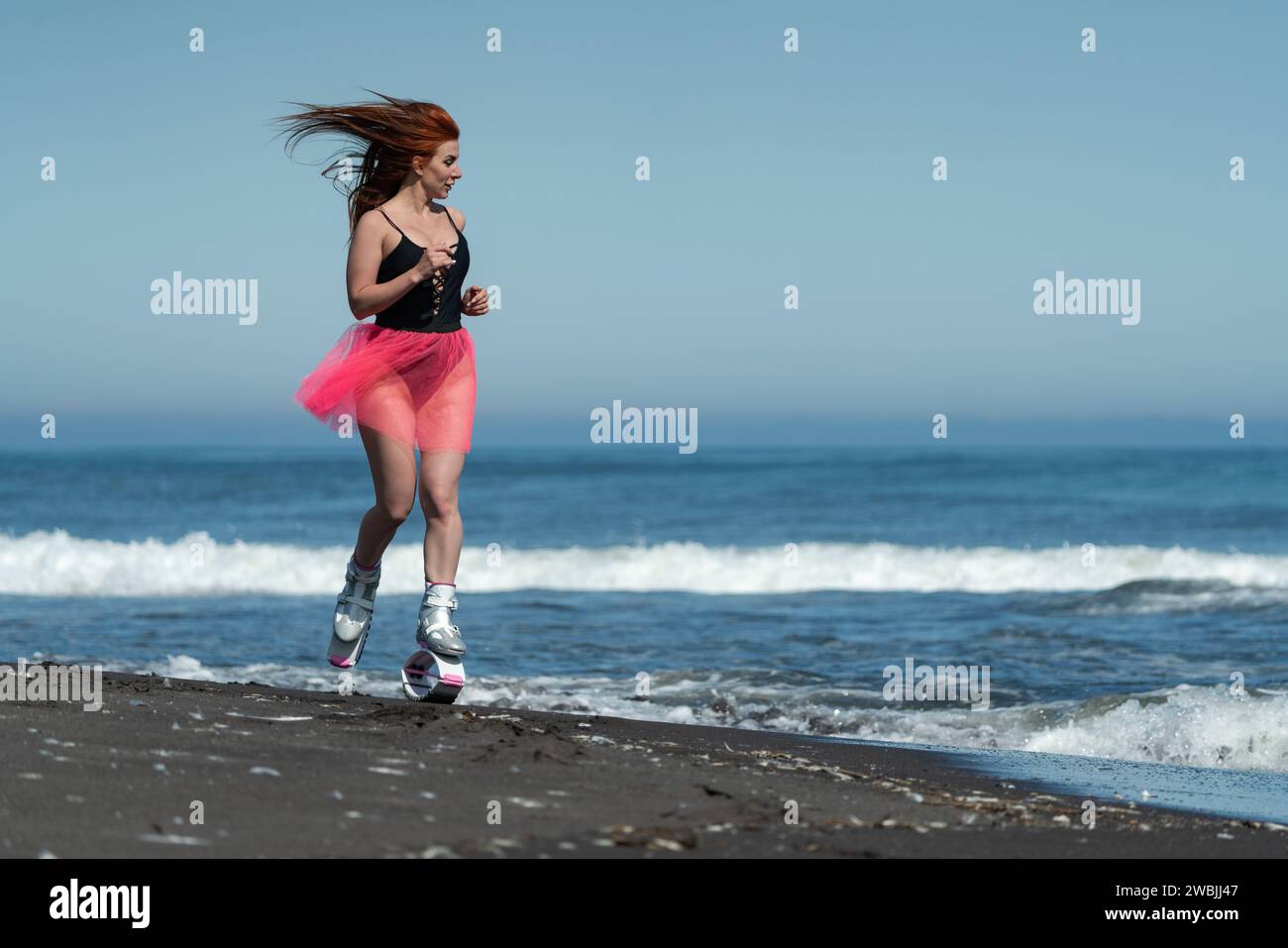 Athletic woman in sports Kangoo Jumps boots, black one piece swimsuit ...