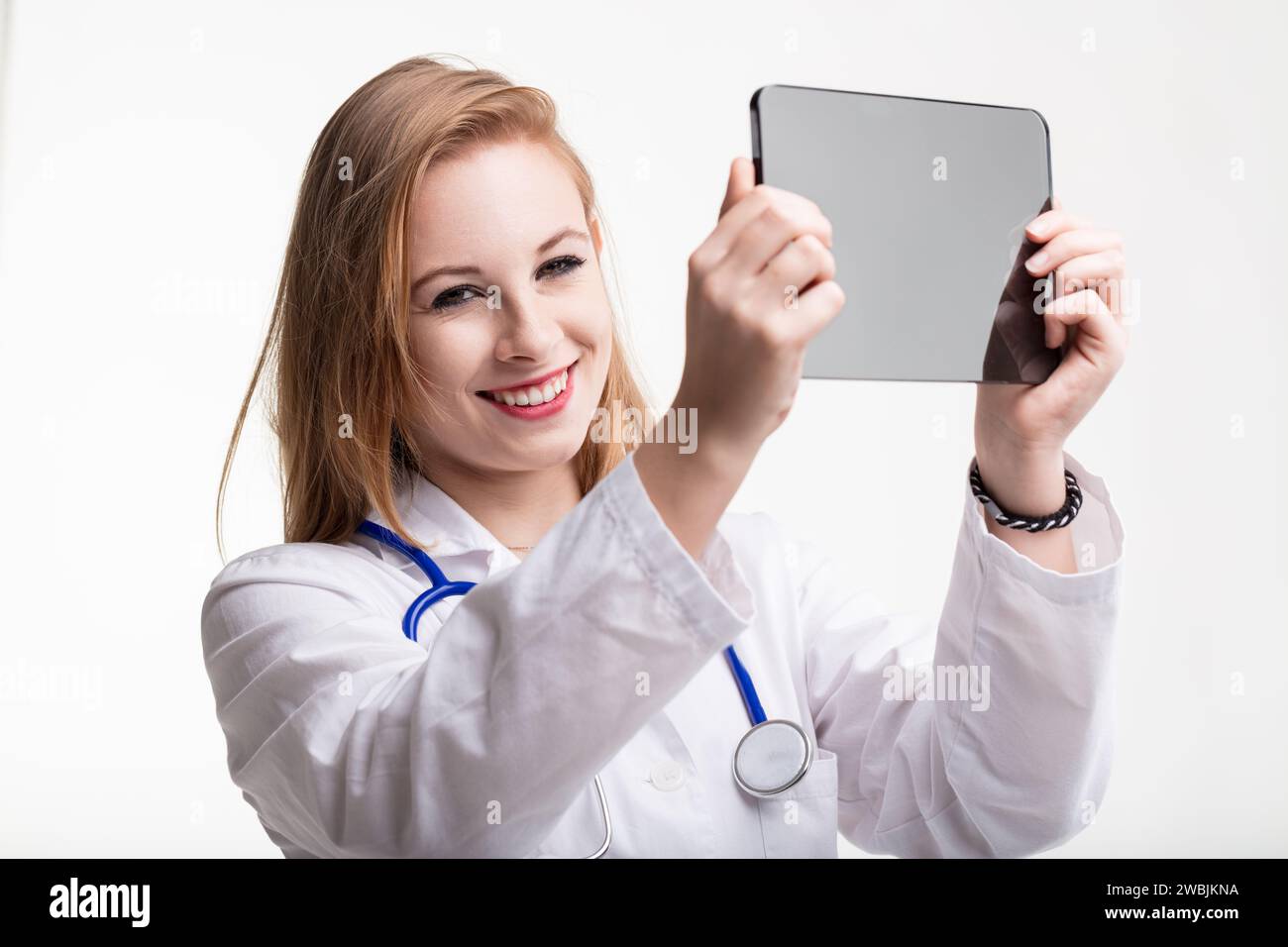 Physician reviewing data on a transparent tablet, a glance towards the ...