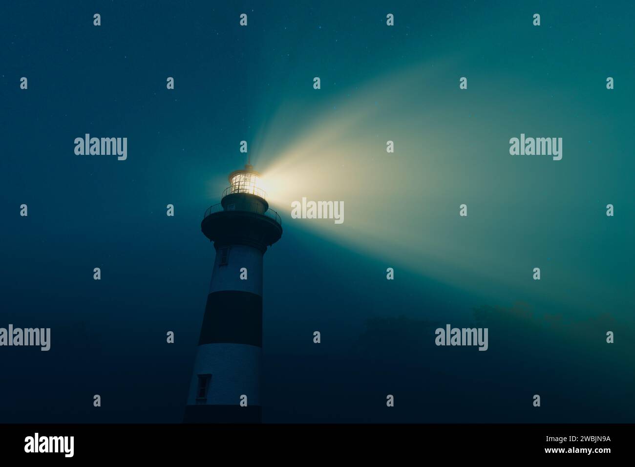 Captivating image of a lighthouse's luminous beam slicing through dense ...