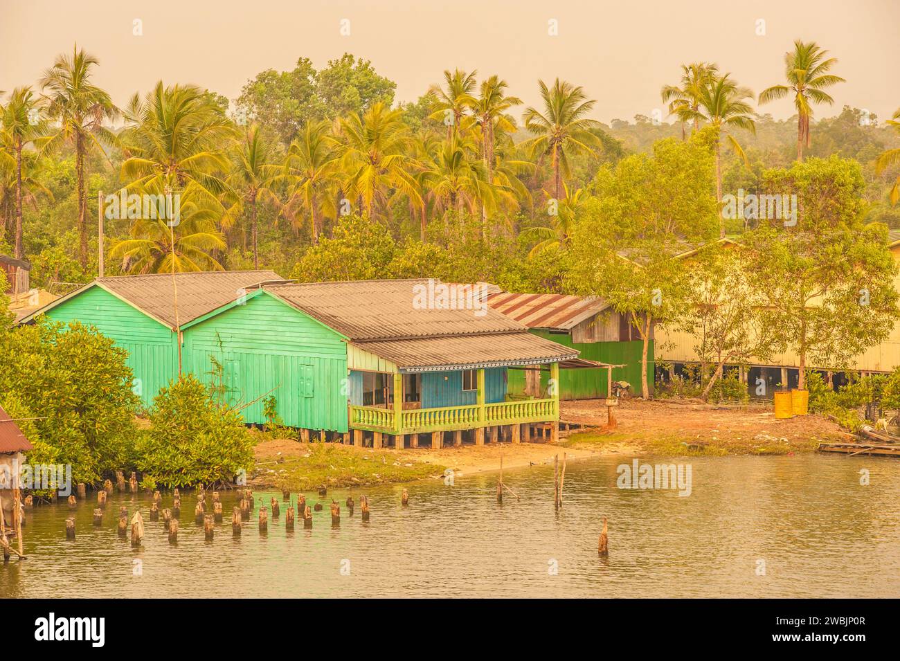 colorful turquoise house on the bank of a river, Southern Cardamom ...
