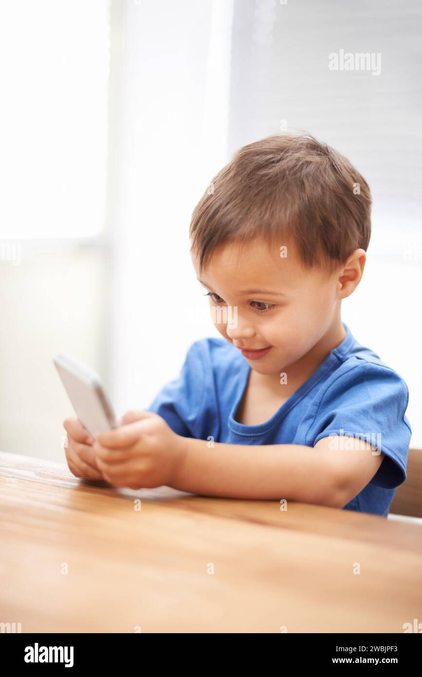 Child, boy and relaxing on smartphone or texting, connection and ...