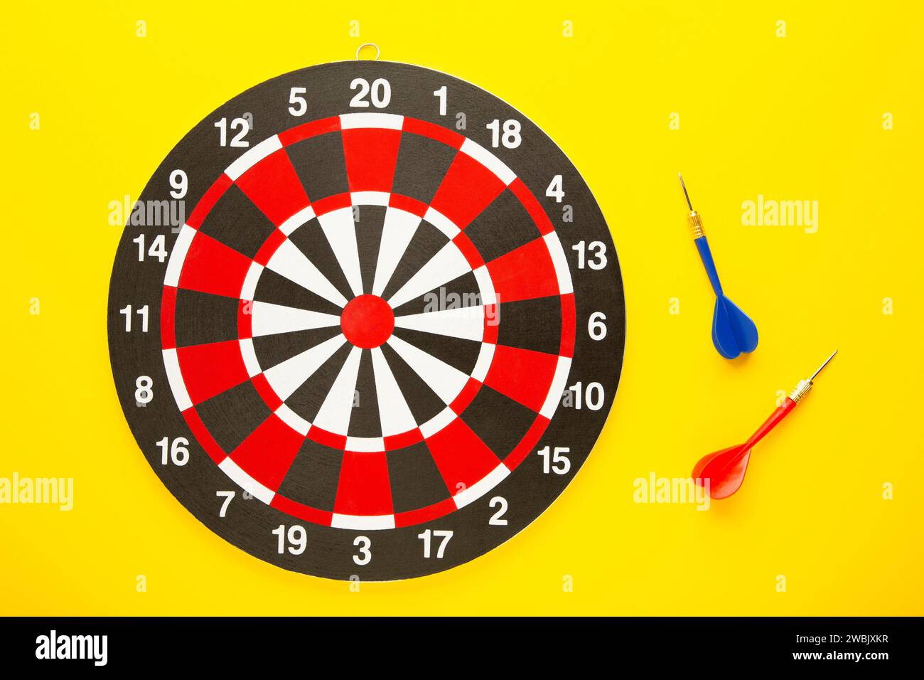 Dart board with blue and red darts on yellow background. Top view Stock ...