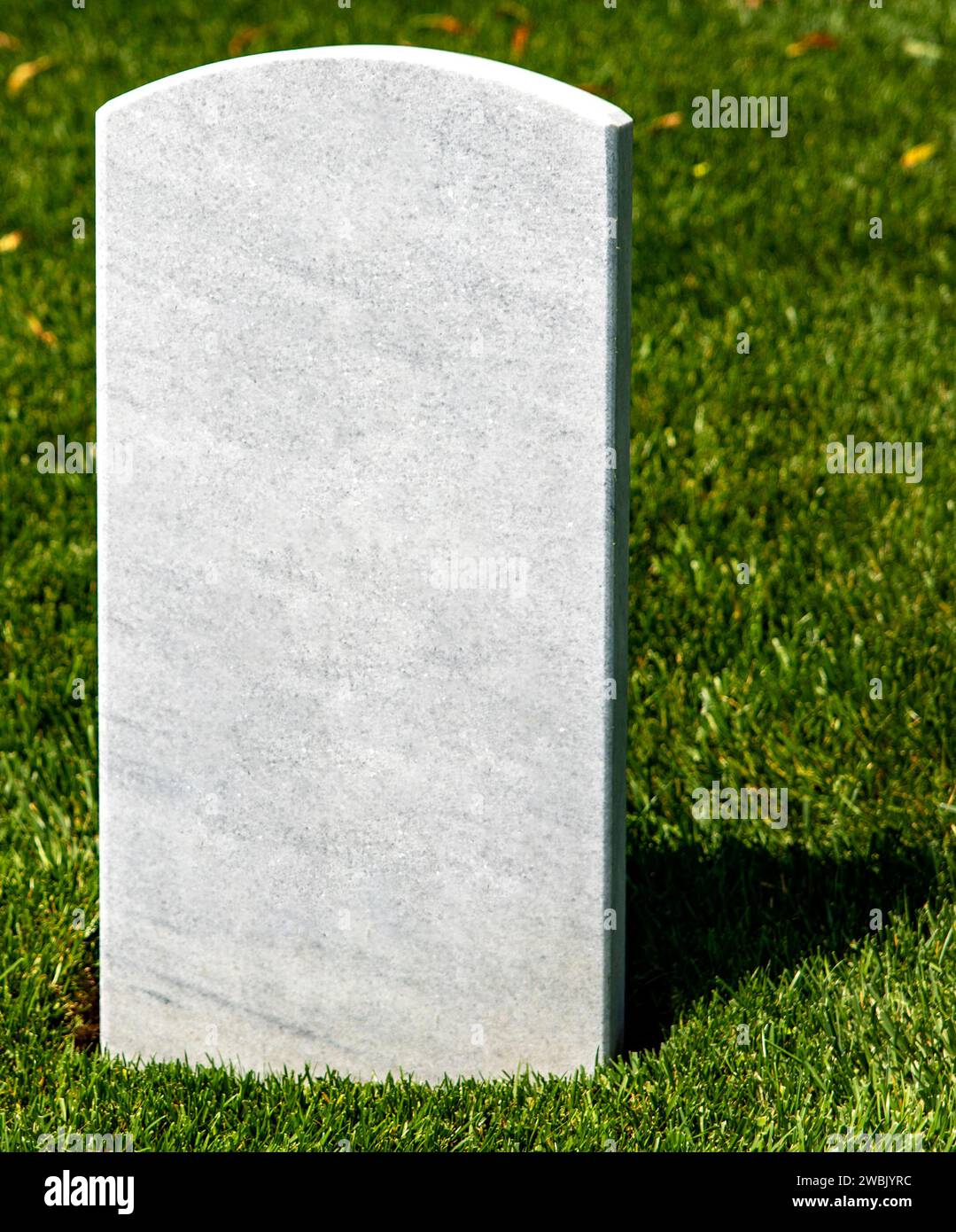 Vertical photo of a white tombstone on a grassy lawn at Arlington ...
