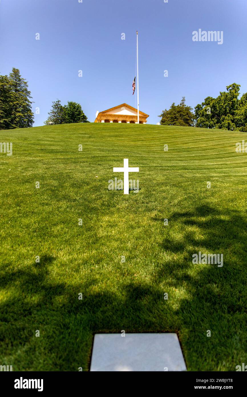 Vertical photo of cross and tomb on a grassy lawn at Arlington National ...