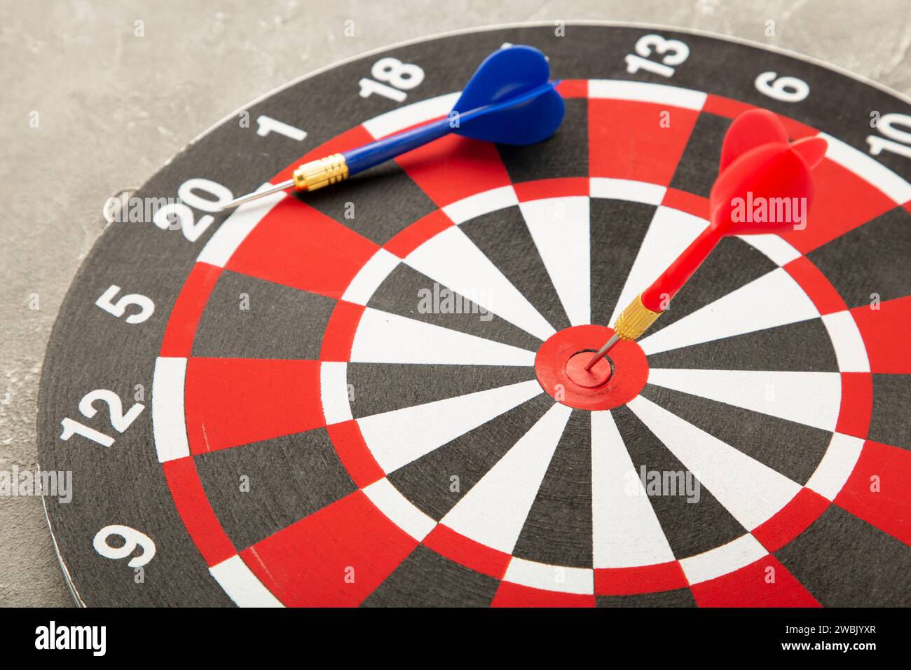 Dart board with darts on grey background. Top view Stock Photo - Alamy
