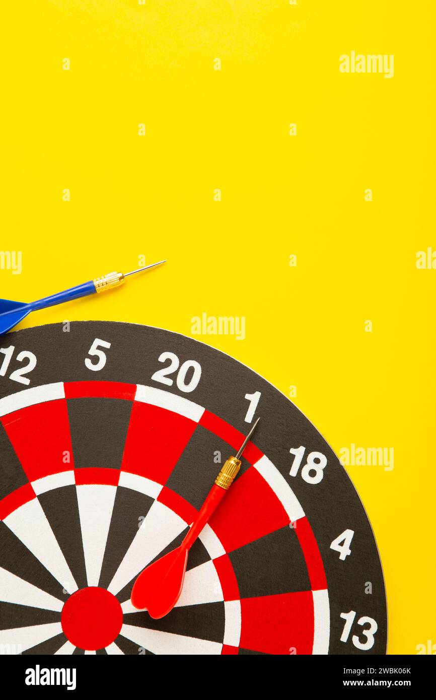 Dart board with darts on yellow background. Top view Stock Photo - Alamy
