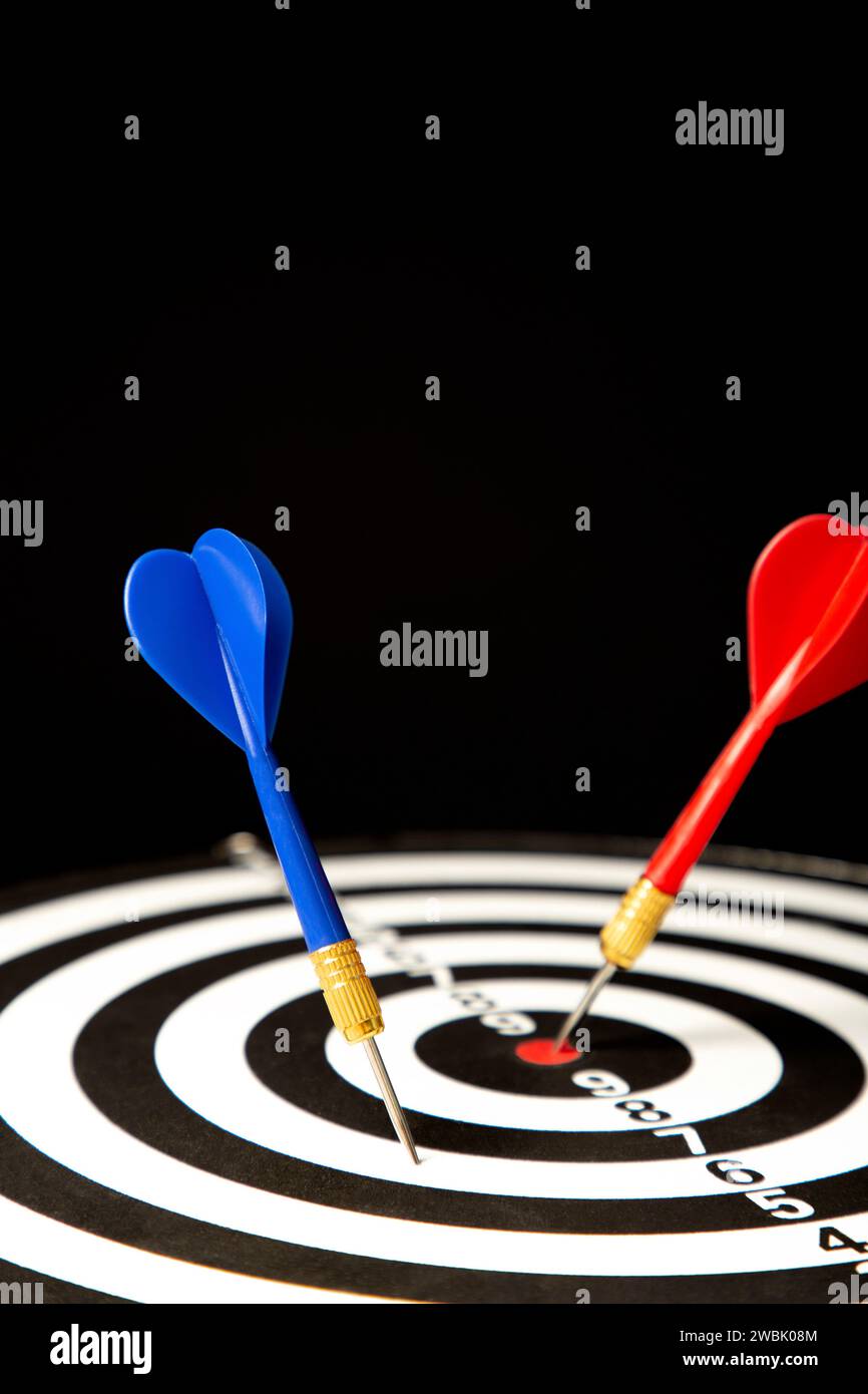Dart board with darts on black background. Top view Stock Photo - Alamy
