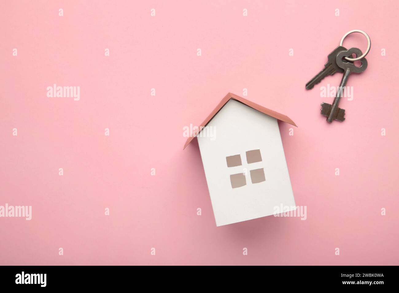 Paper house and key on pink background with copy space. Top view Stock ...