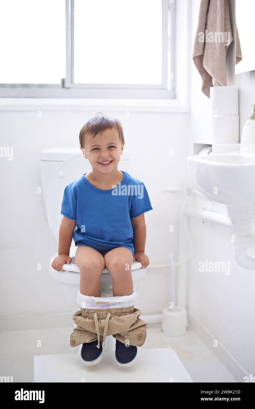 Boy kid, potty training and toilet with sitting, diaper and happy in ...