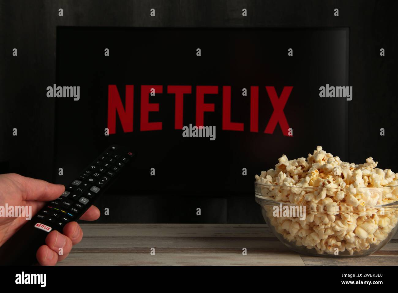 Nikolaev, Ukraine - November 20, 2021. Man with TV remote control in ...