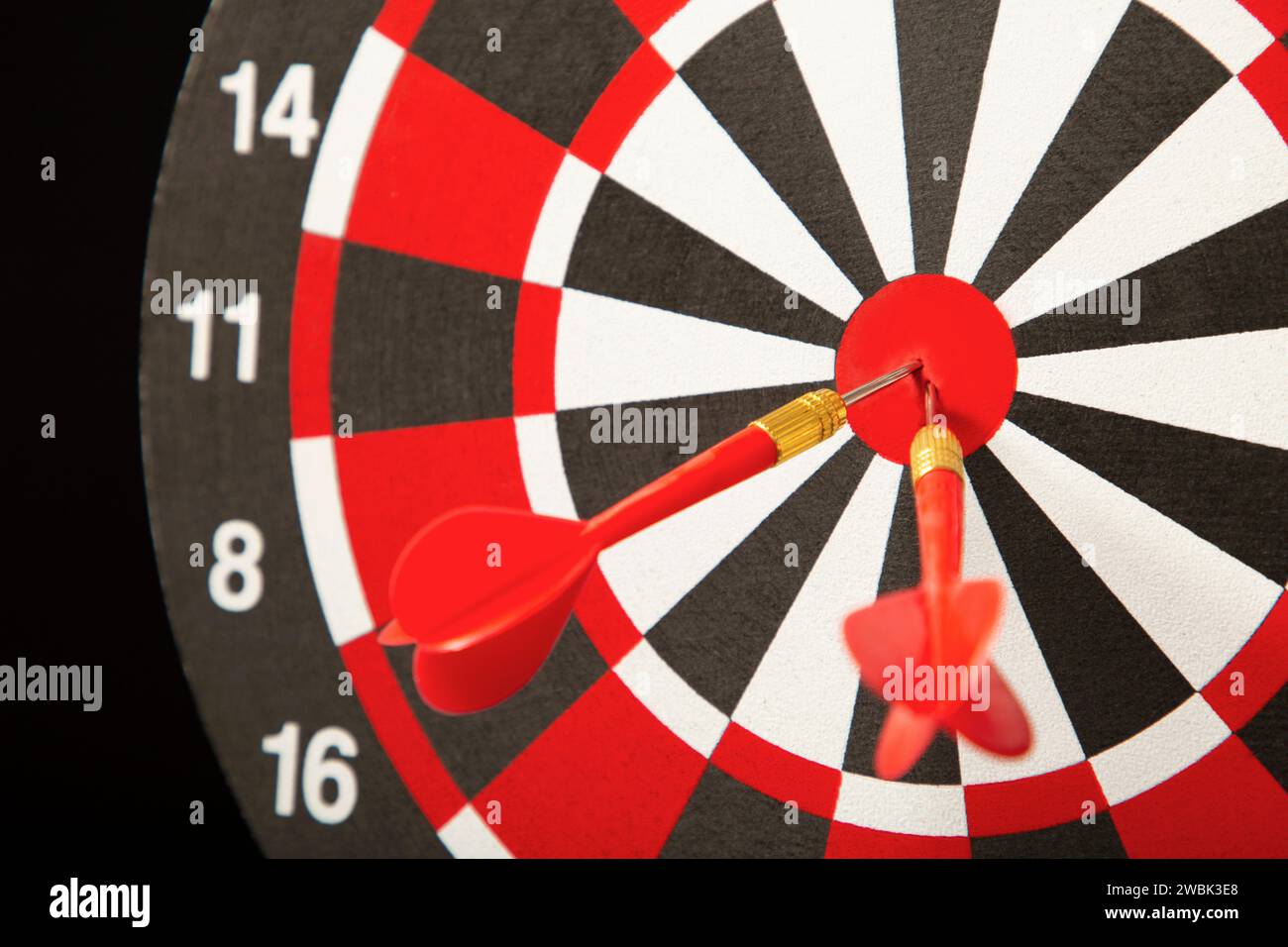 Dart board with darts on black background. Top view Stock Photo - Alamy