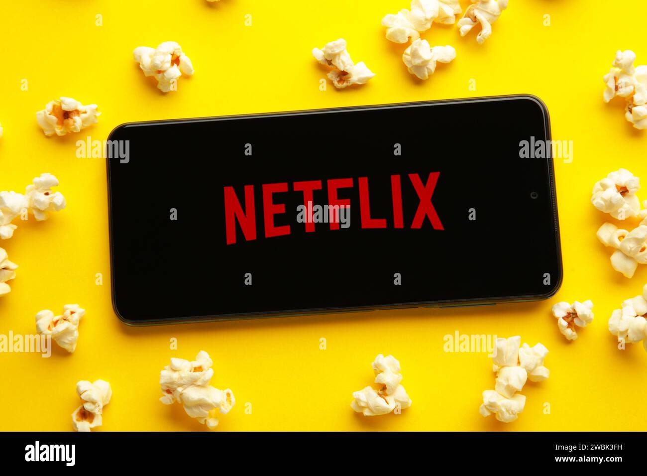 Smartphone with Netflix logo and popcorn on yellow background. Netflix ...