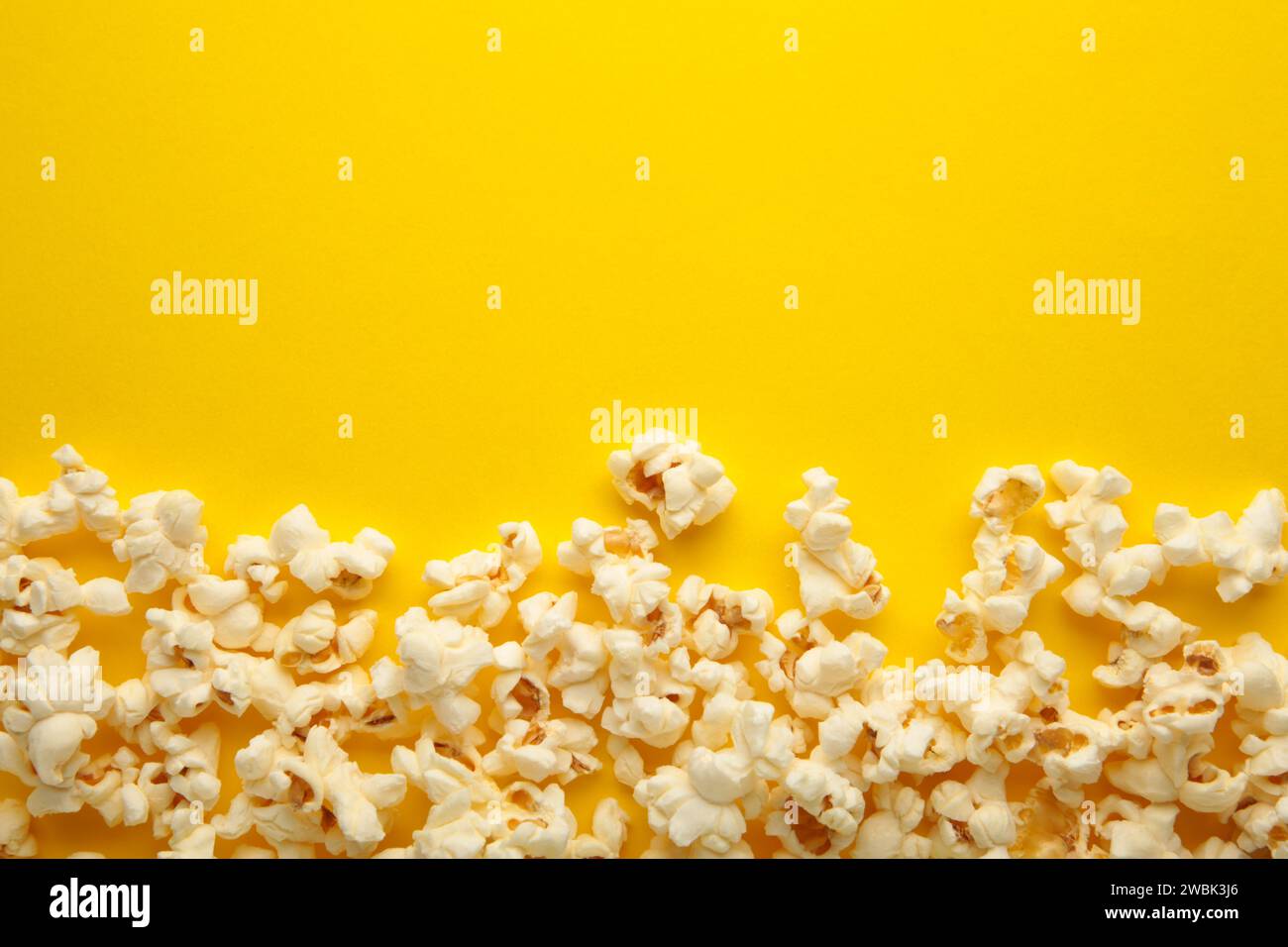 Popcorn on yellow background with copy space. Top view Stock Photo - Alamy