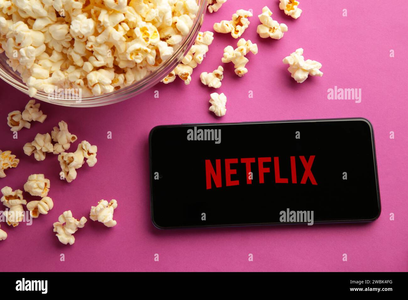 Smartphone with Netflix logo and popcorn on purple background. Netflix ...