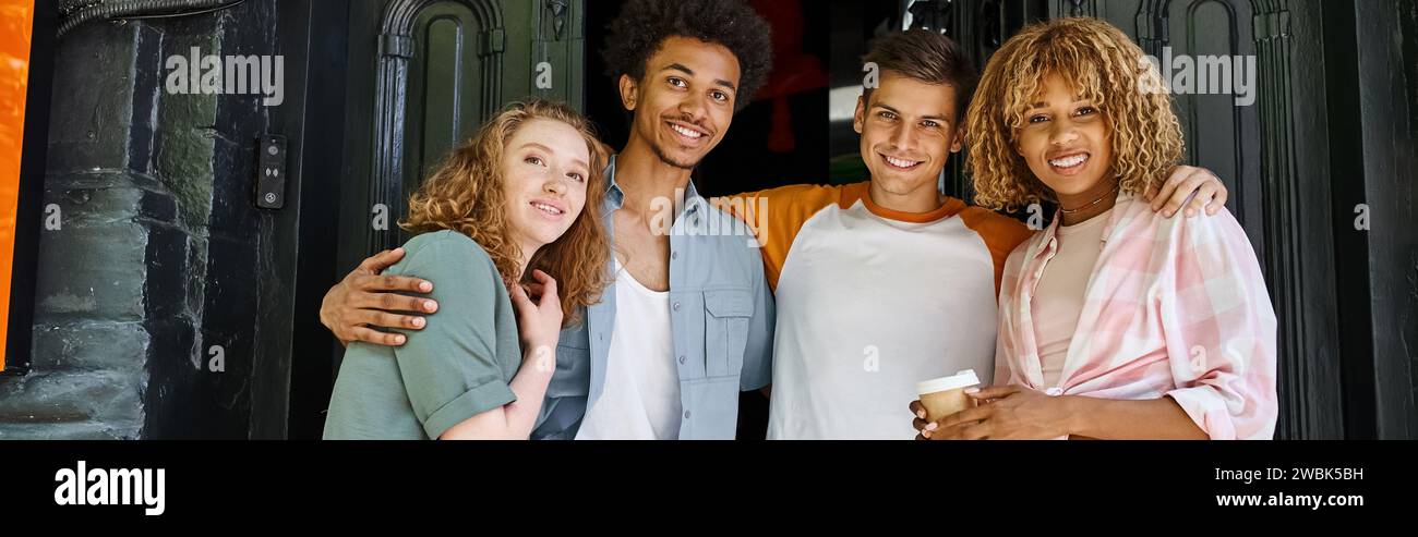 smiling and stylish multiethnic students embracing near campus on city ...
