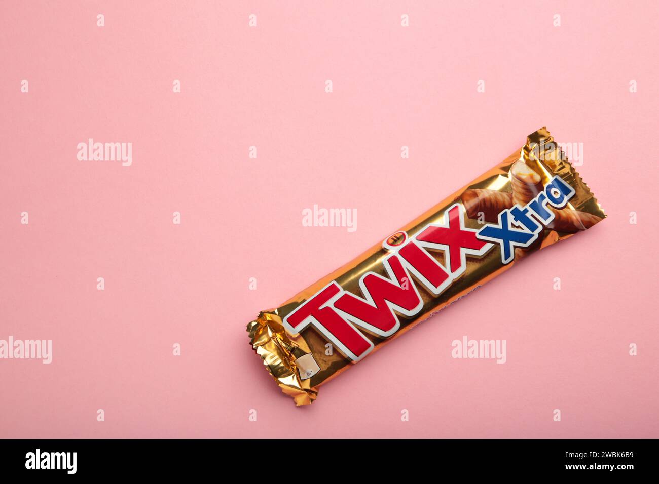 Long milk chocolate bars with caramel filling on pink background. Twix ...