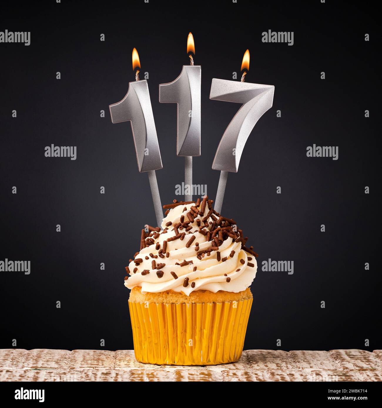 Birthday candle number 117 - Anniversary cupcake on black background ...