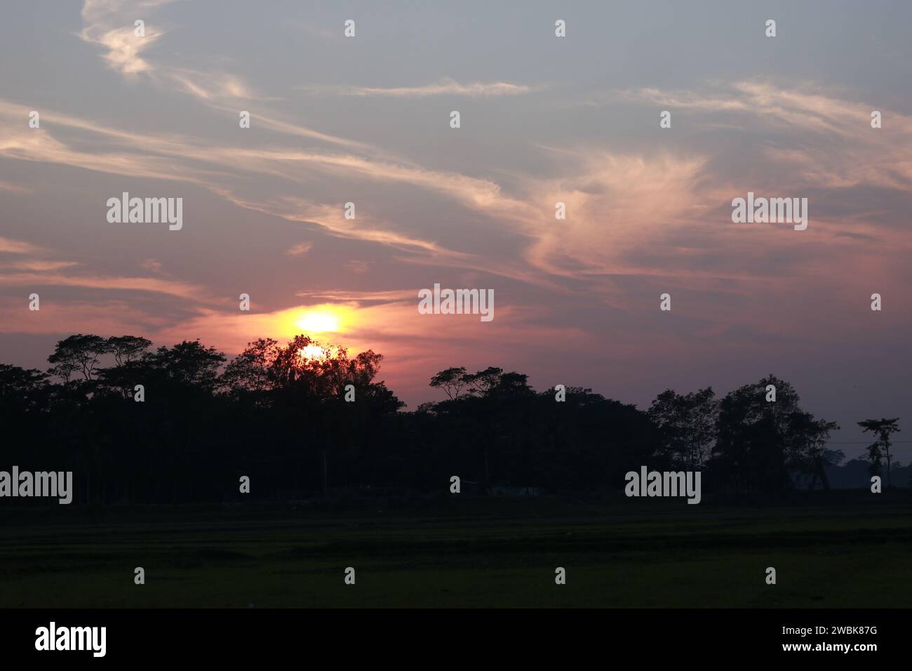 Winter sunrise of rural Bengal. We see the sky, some clouds that light ...