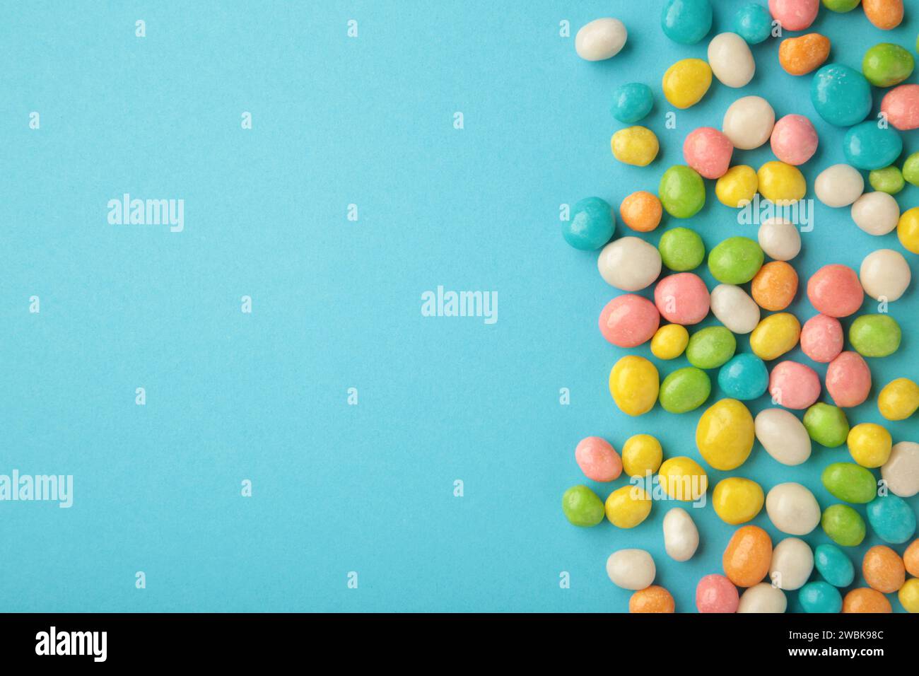 Colorful chocolate candy pills withs space on blue background. Top view ...