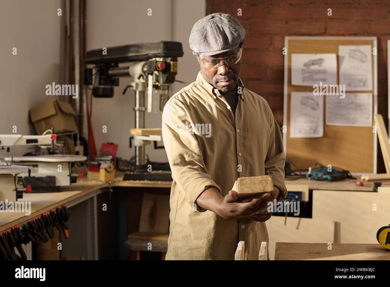African American senior man as skilled carpenter inspecting wood board ...