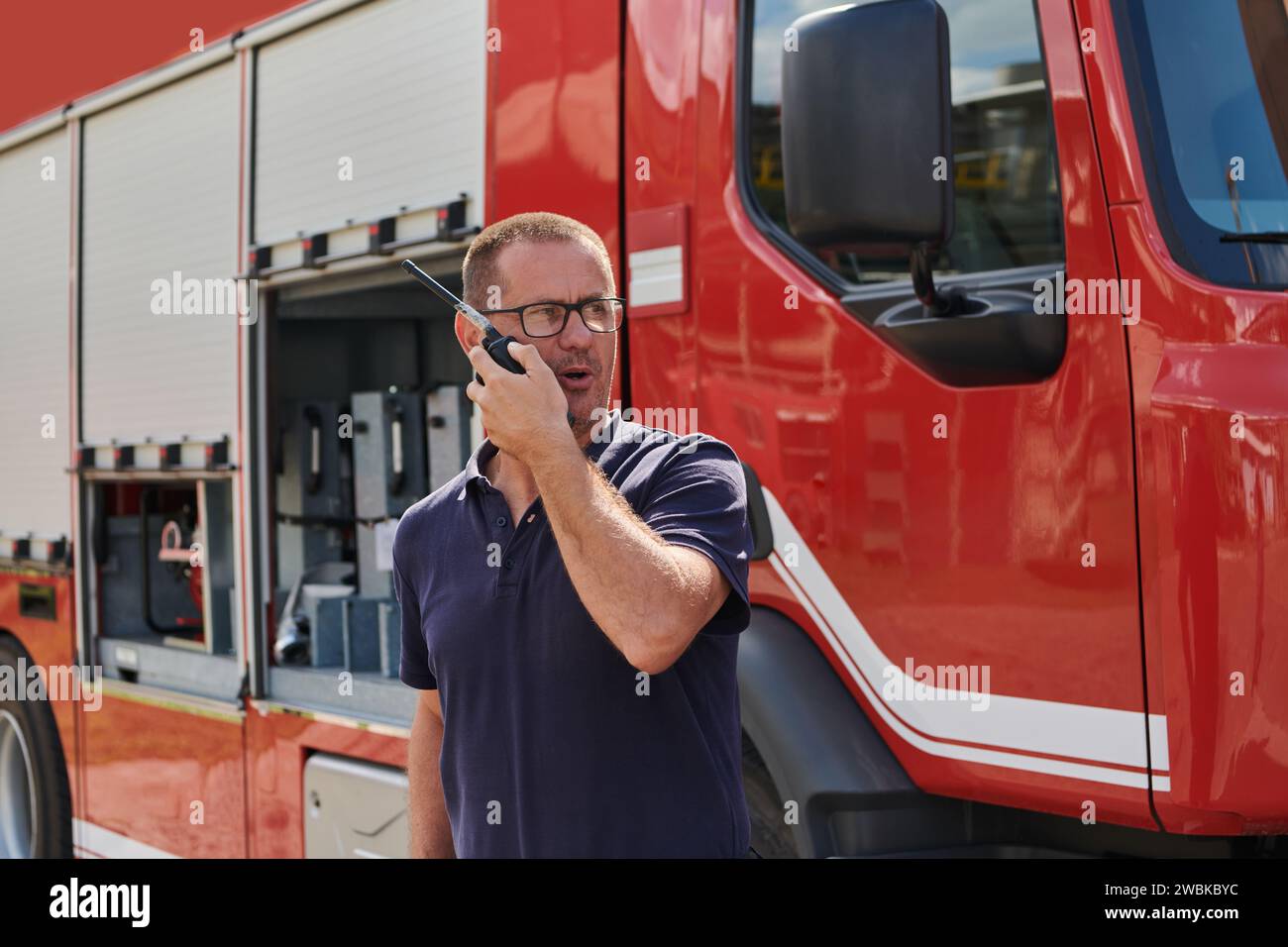 A dedicated firefighter, captured in a moment of communication, stands ...