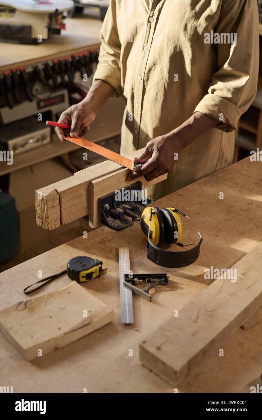 High angle closeup of unrecognizable Black man building wooden ...