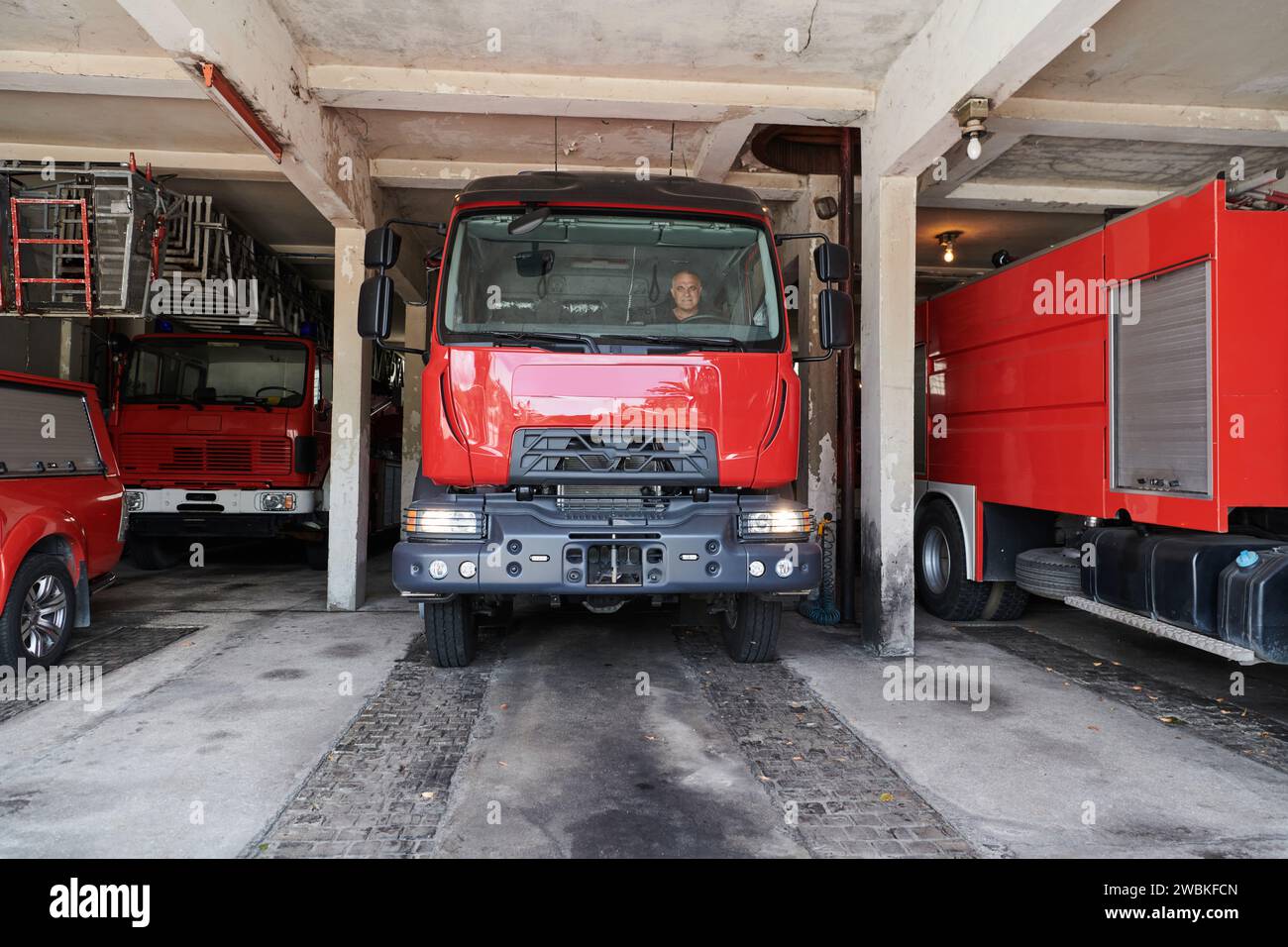 A dedicated firefighter preparing a modern firetruck for deployment to ...