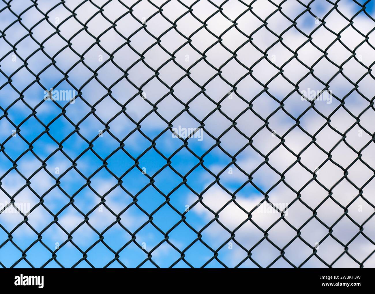 Chain link fence with blue sky and clouds in the background Stock Photo ...