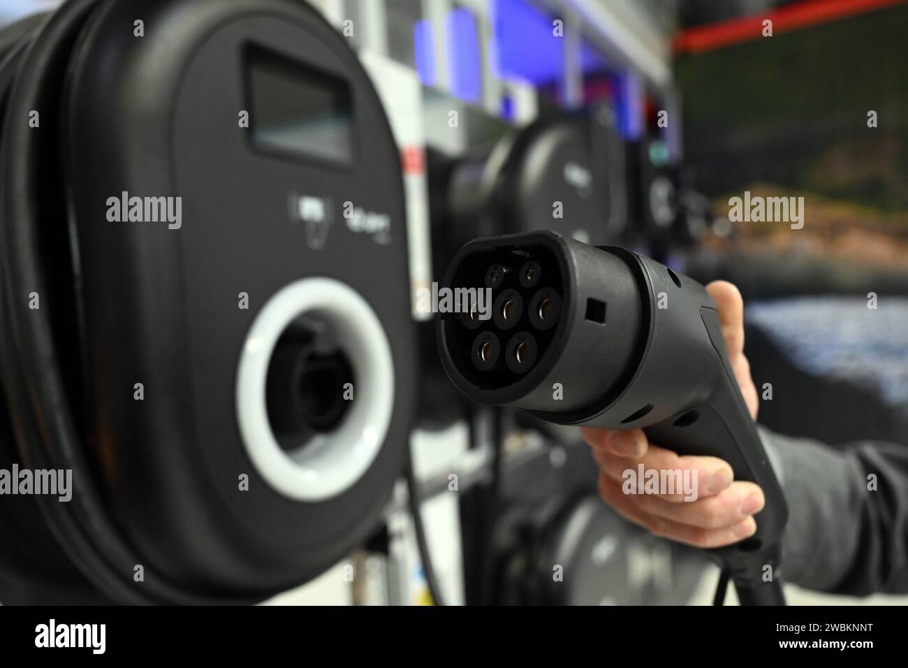 Essen, Germany. 11th Jan, 2024. An Eon employee holds a charging plug ...