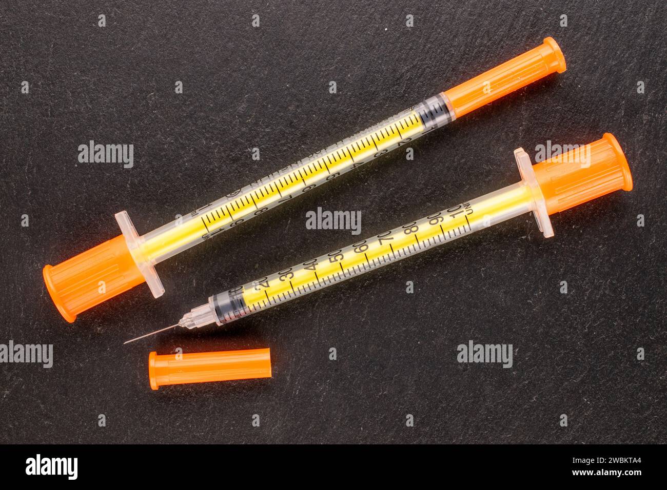 Two medical syringes on slate stone, macro, top view Stock Photo - Alamy